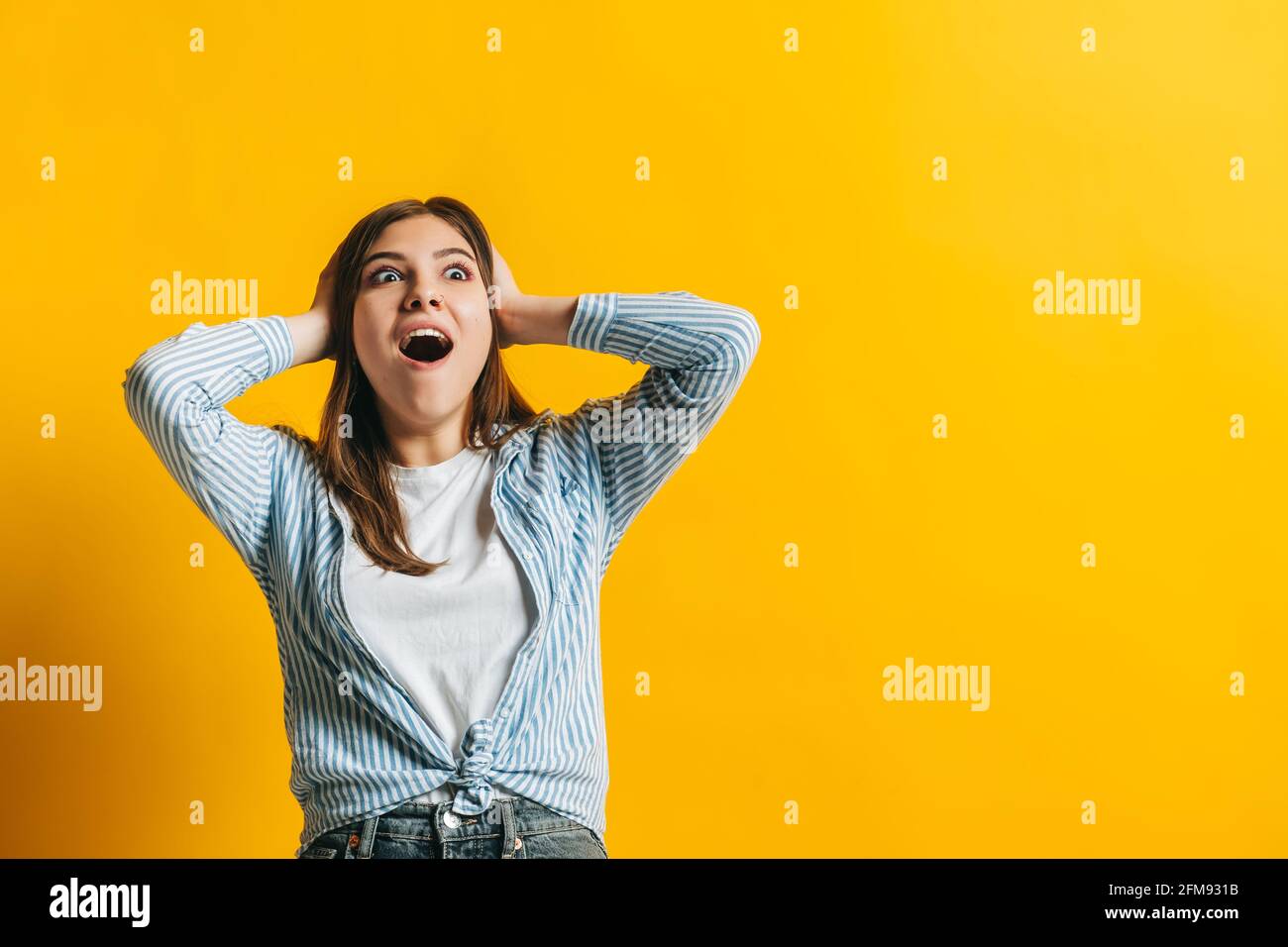 Portrait of excited young woman surprised by something expresses shock ...