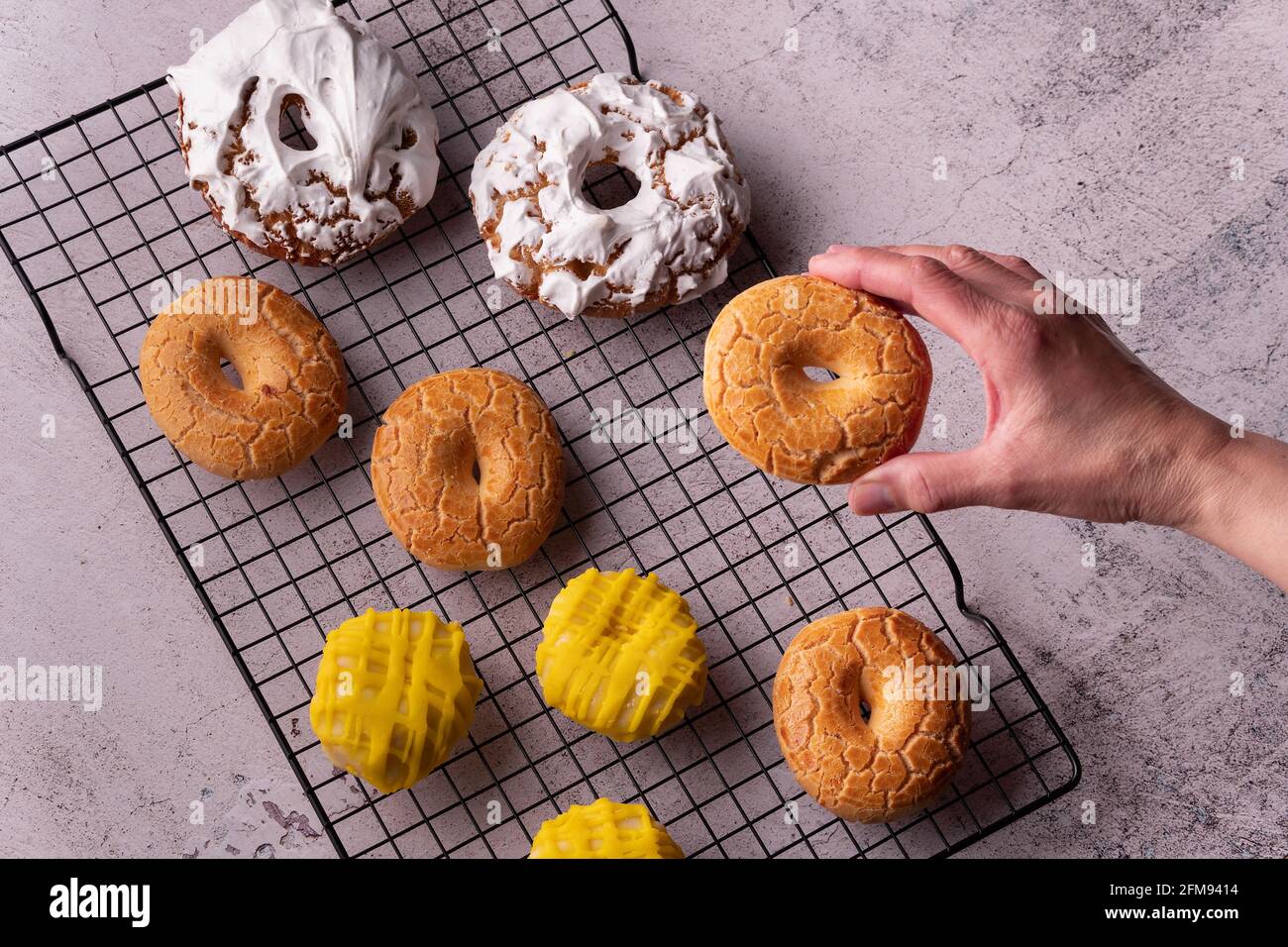 Man's hand holding a delicious donut in the bakery full of glazed ...
