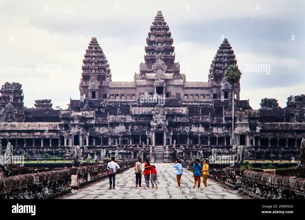 Visitors on their way to the huge temple complex of Angkor Wat with its ...