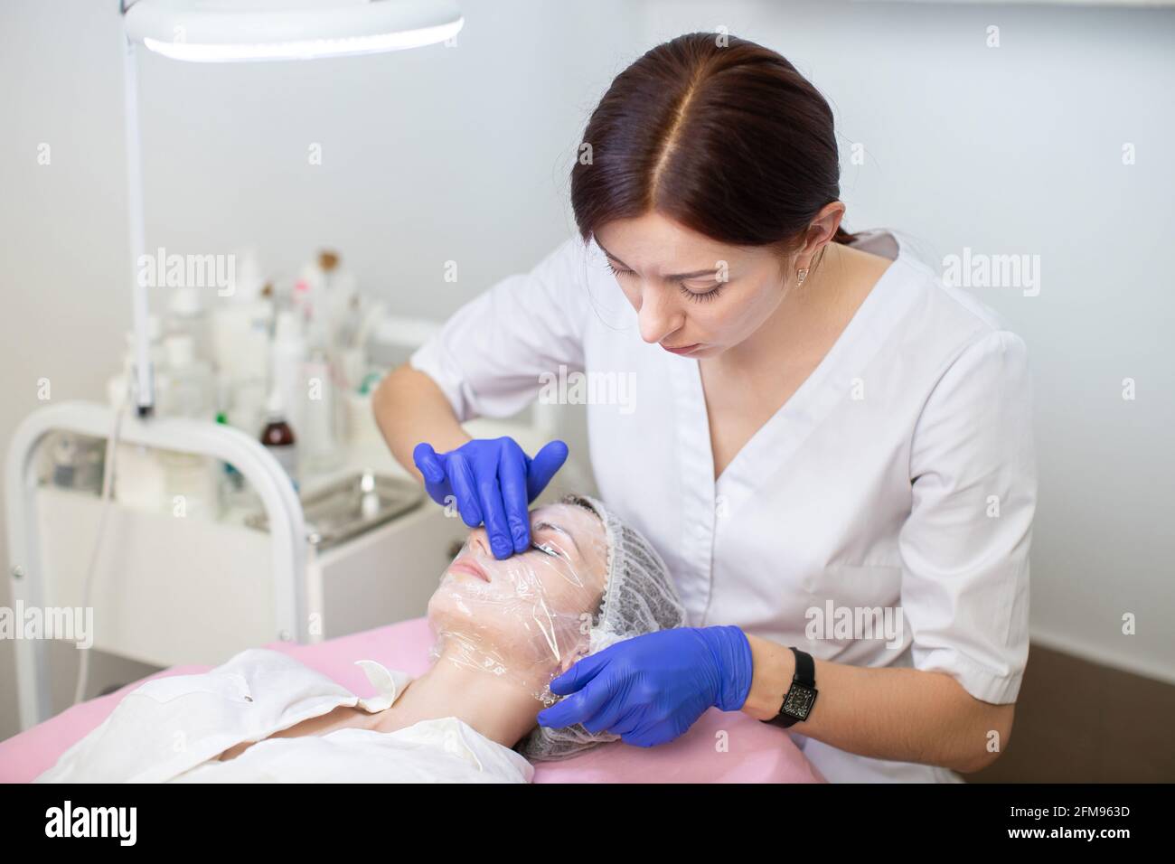 Close up of professional doctor dermatologist in blue rubber gloves ...