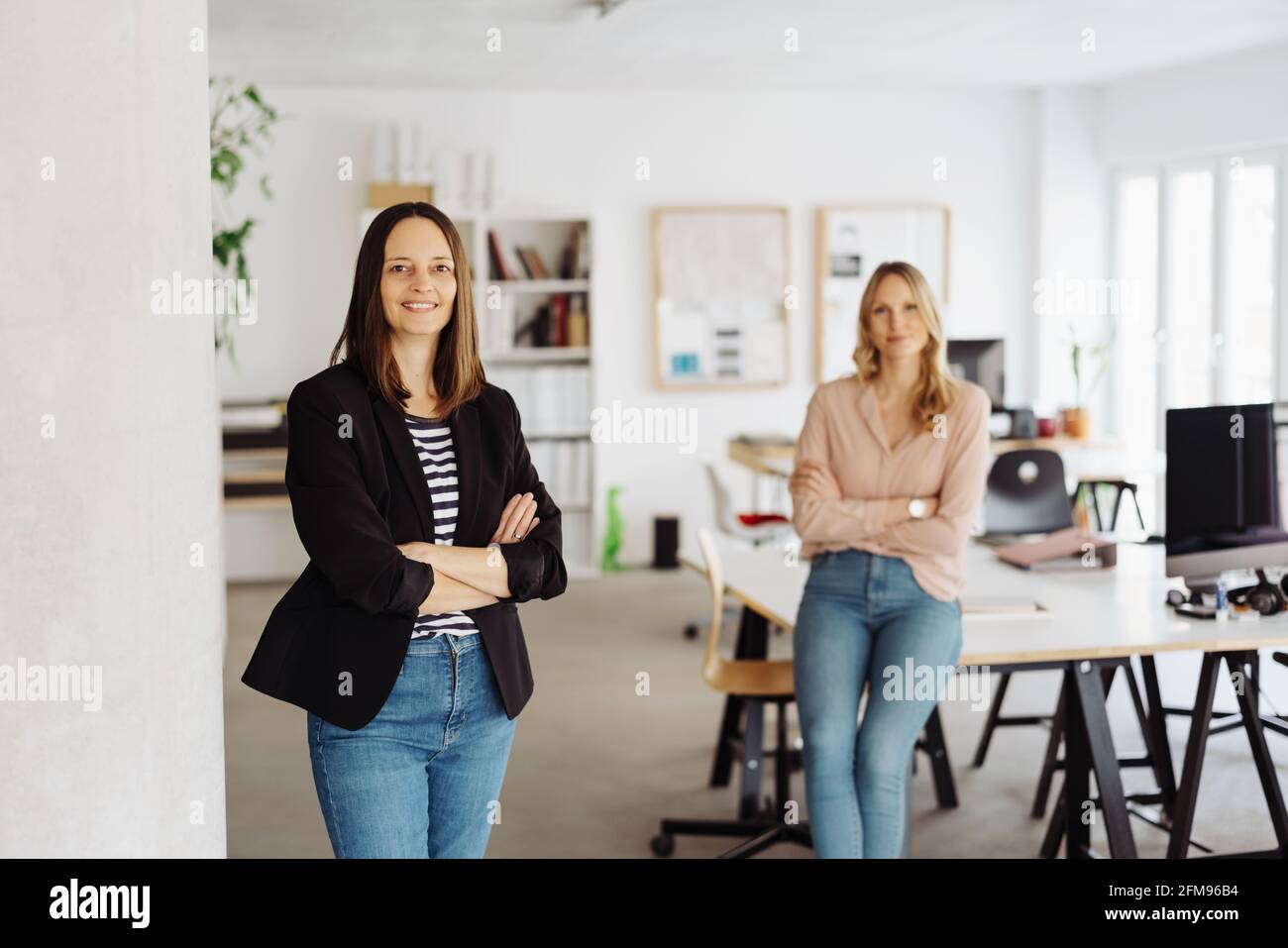Two relaxed successful confident businesswomen relaxing in an office ...