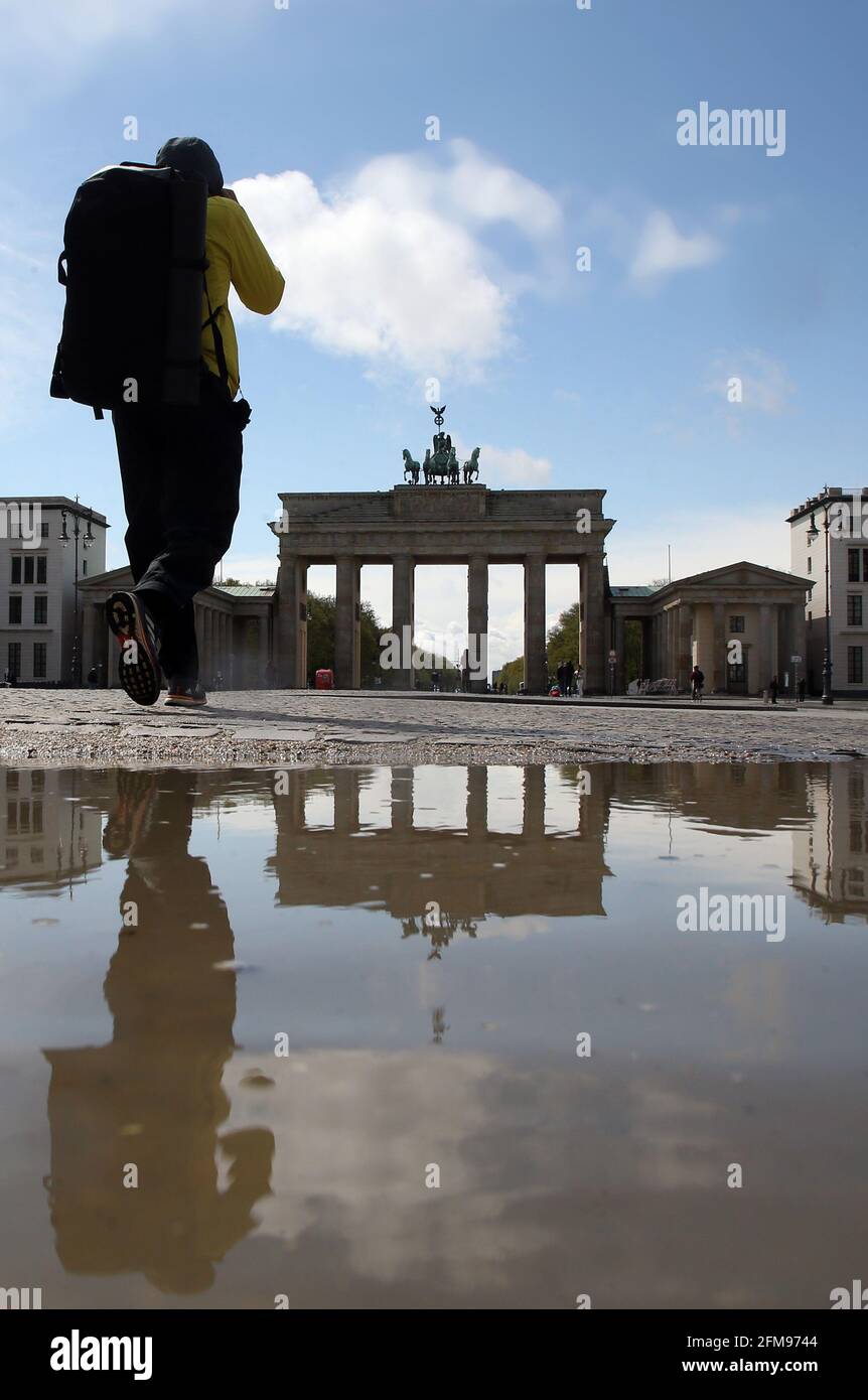 Berlin, Germany. 07th May, 2021. After a heavy rain shower, people walk ...