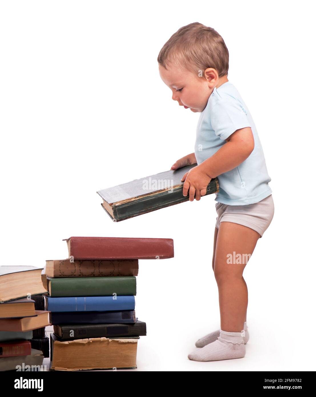 Boy stands near a stack of books for an educational portrait - isolated ...