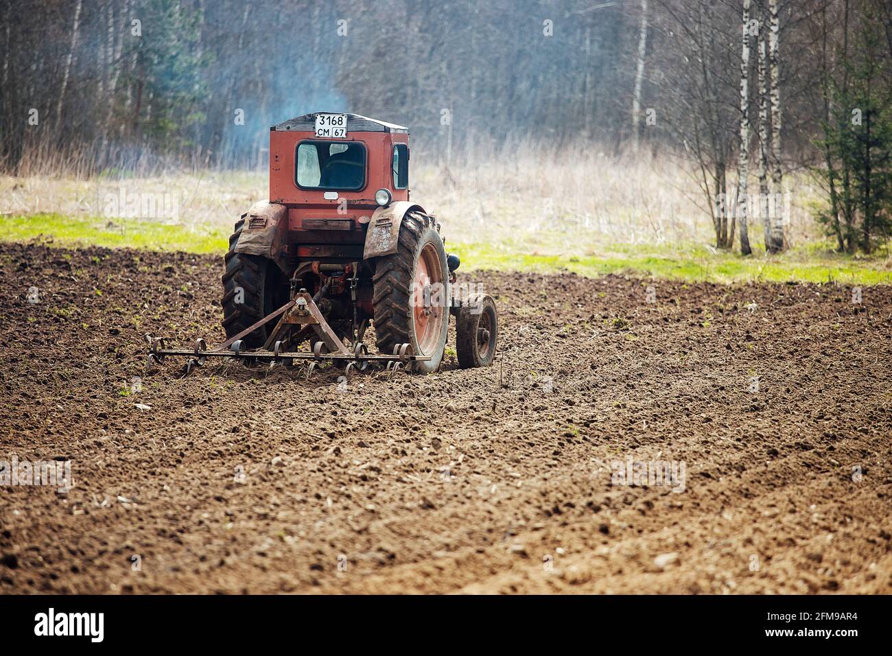 plow tractor plows the land for planting agricultural plants. the ...