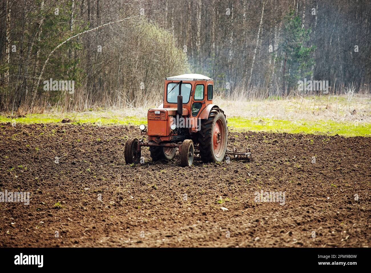 a tractor plows a field. preparation of agricultural land for planting ...