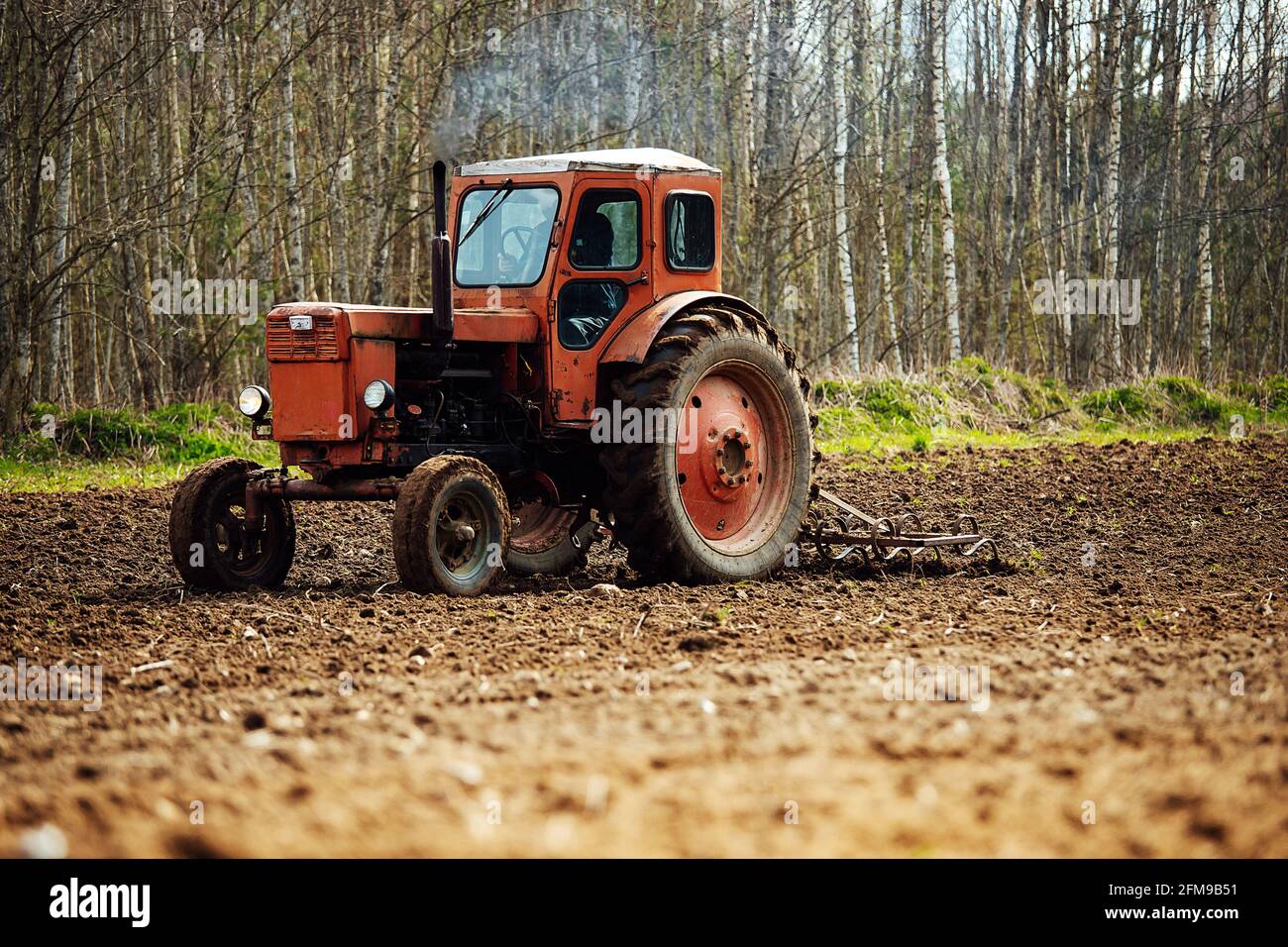 a tractor plows a field. preparation of agricultural land for planting ...