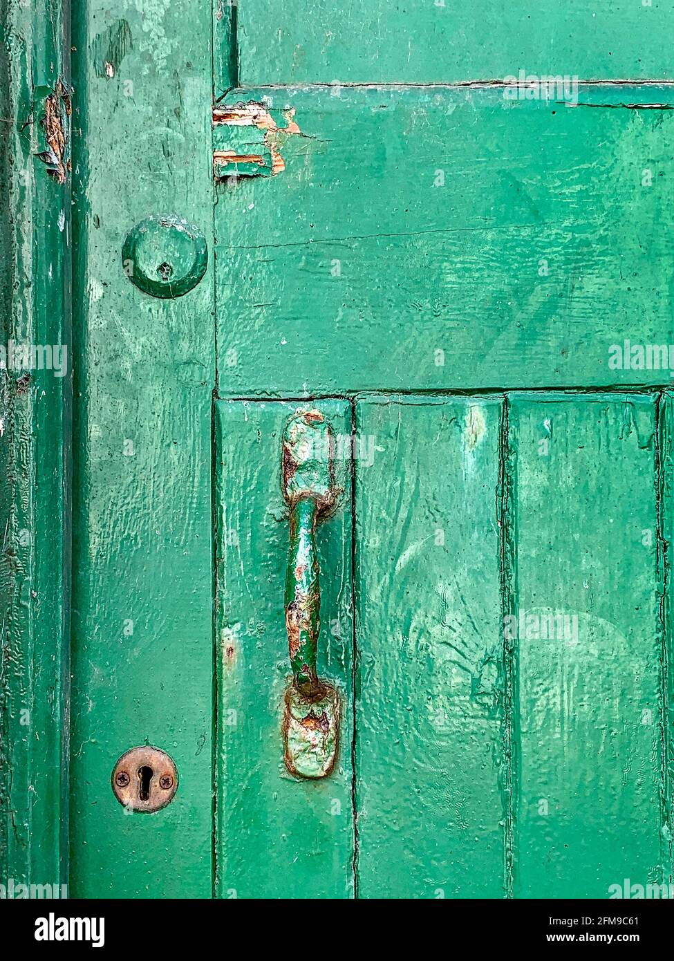 Green painted wooden doorway with handle, keyhole and key lock rim ...
