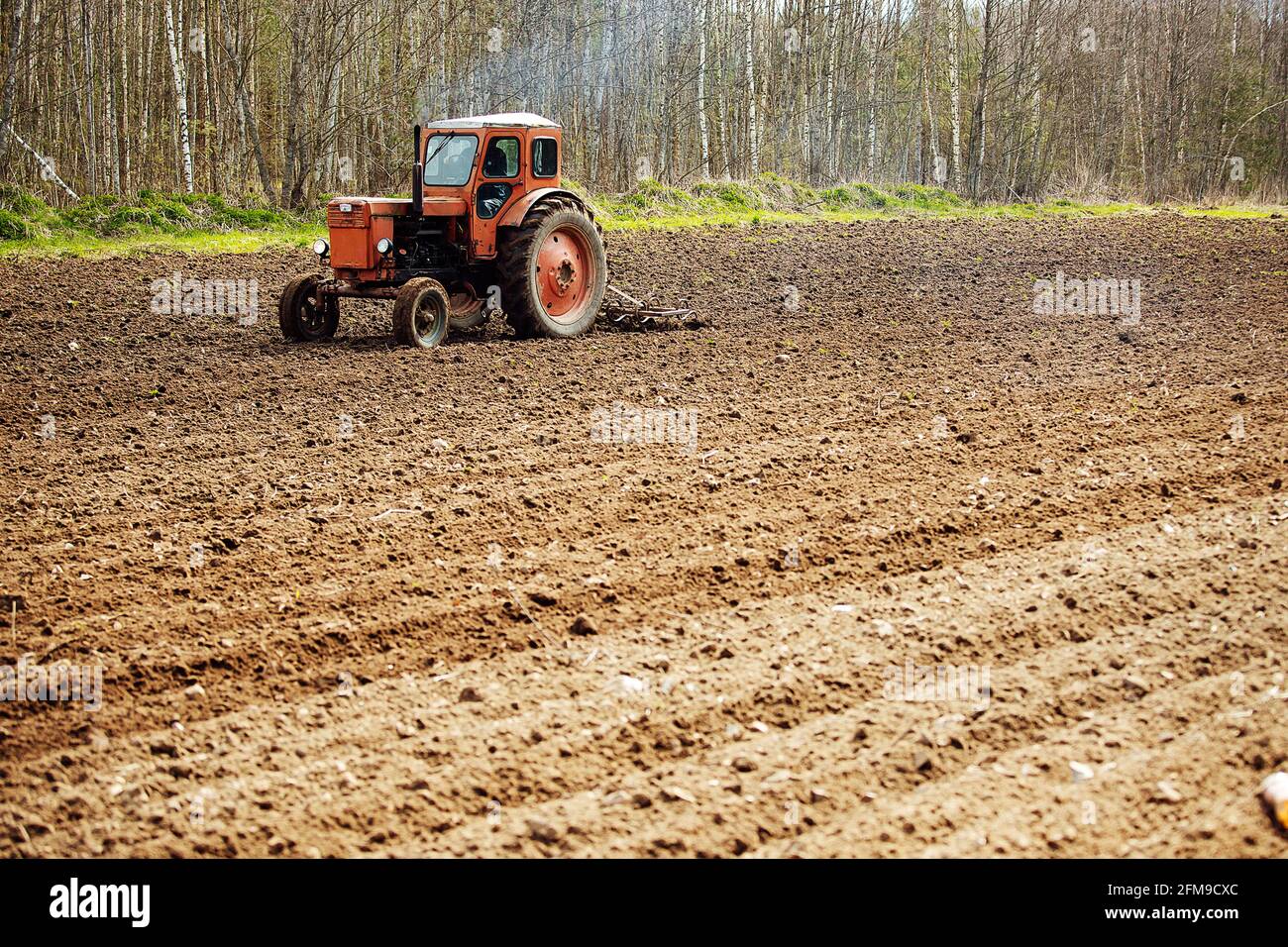 a tractor plows a field. preparation of agricultural land for planting ...