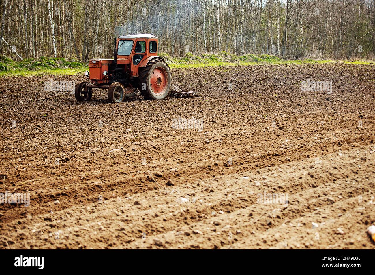 a tractor plows a field. preparation of agricultural land for planting ...