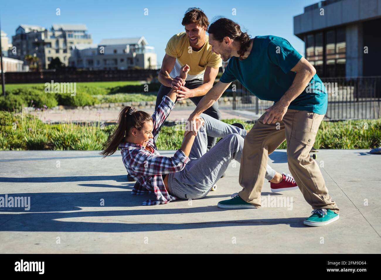 Three happy caucasian female and male friends messing around in the sun ...