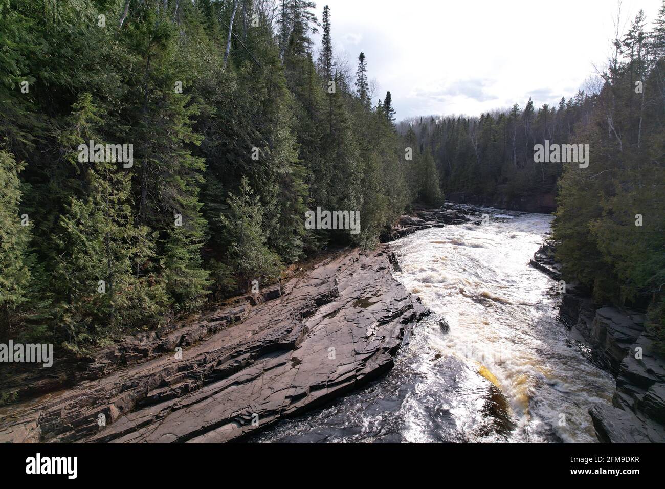 High angle shot of a landscape with a river and forests on both sides ...