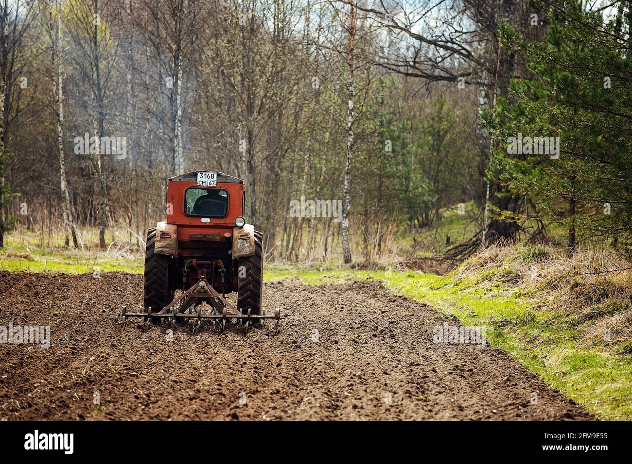 a tractor plows a field. preparation of agricultural land for planting ...