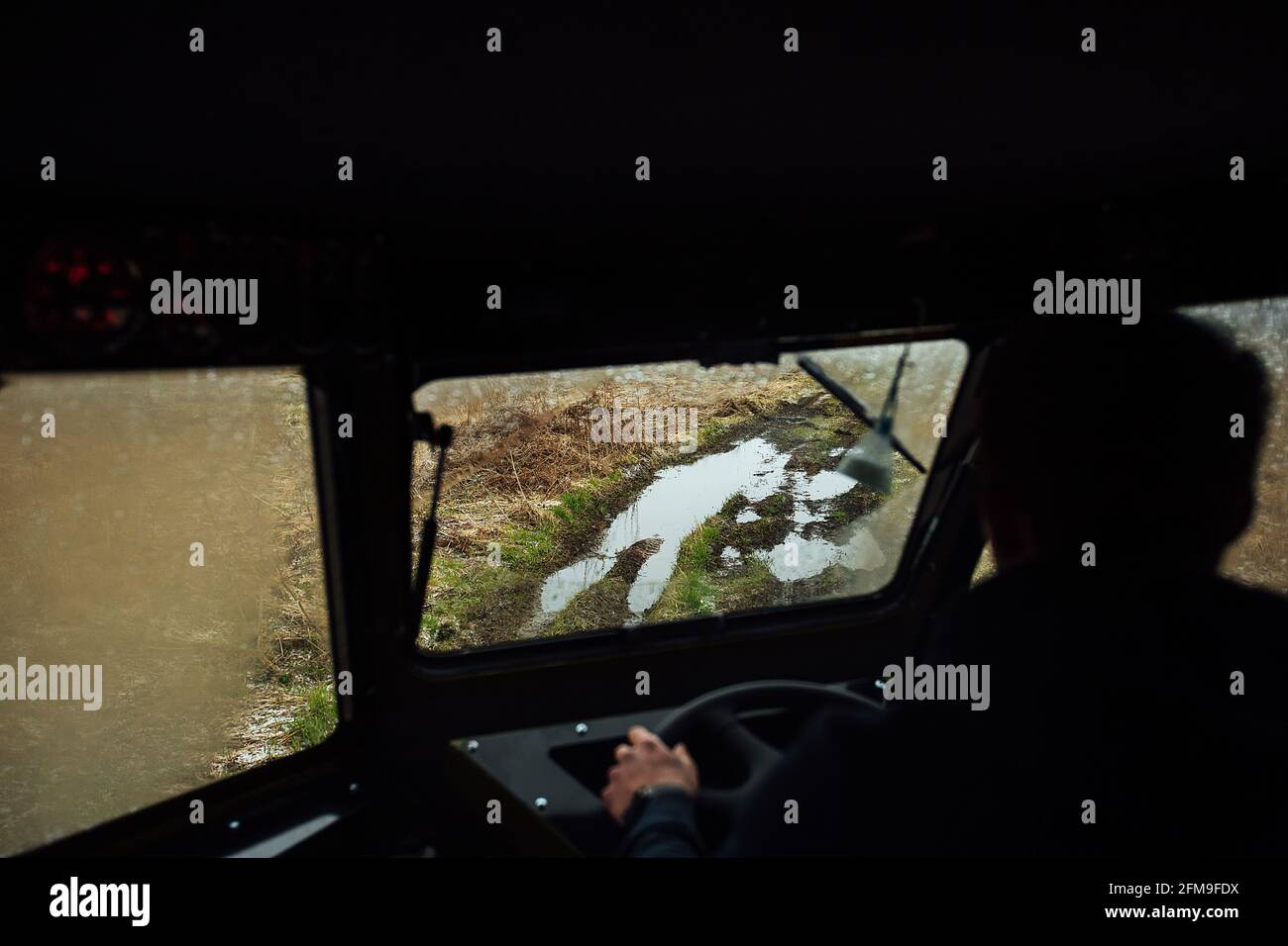 the driver is driving off-road. view from the interior of a four-wheel ...