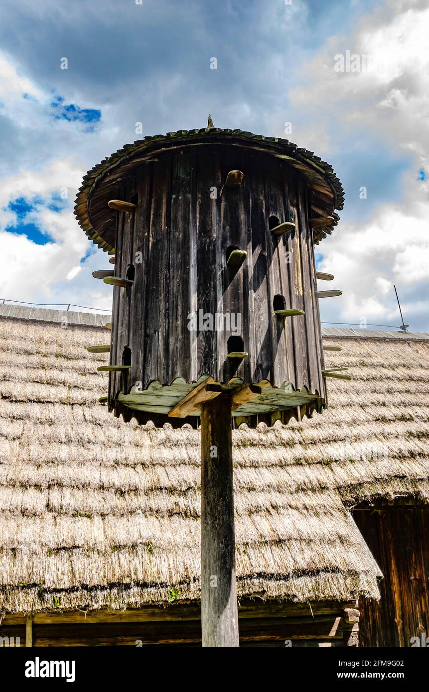 Vintage weathered wooden rounded dovecote with thatched roof on ...