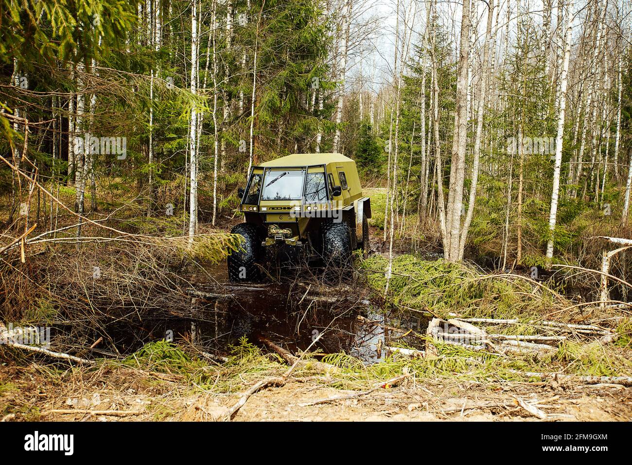 a four-wheel drive all-terrain vehicle drives through the forest ...