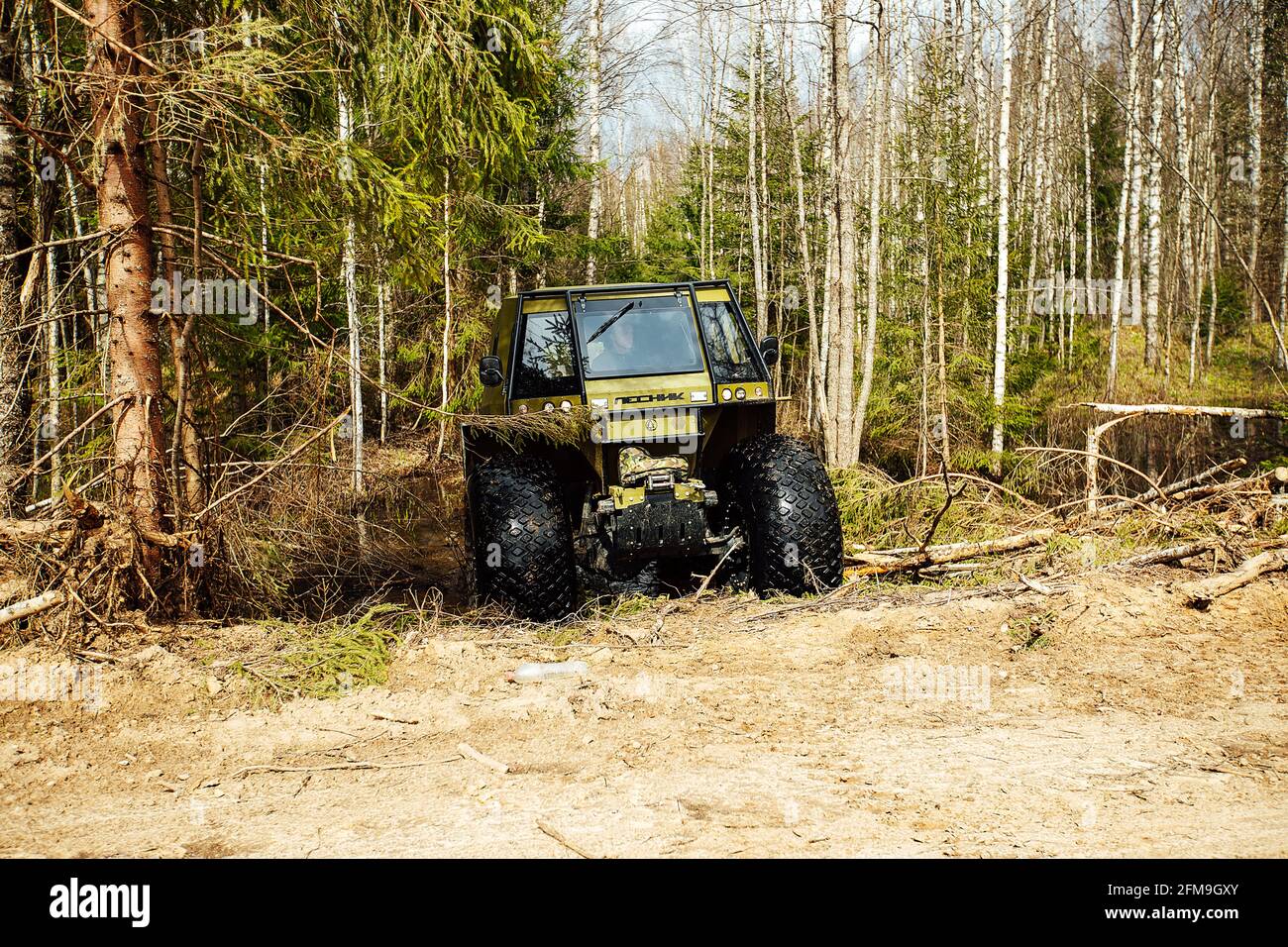 a four-wheel drive all-terrain vehicle drives through the forest ...