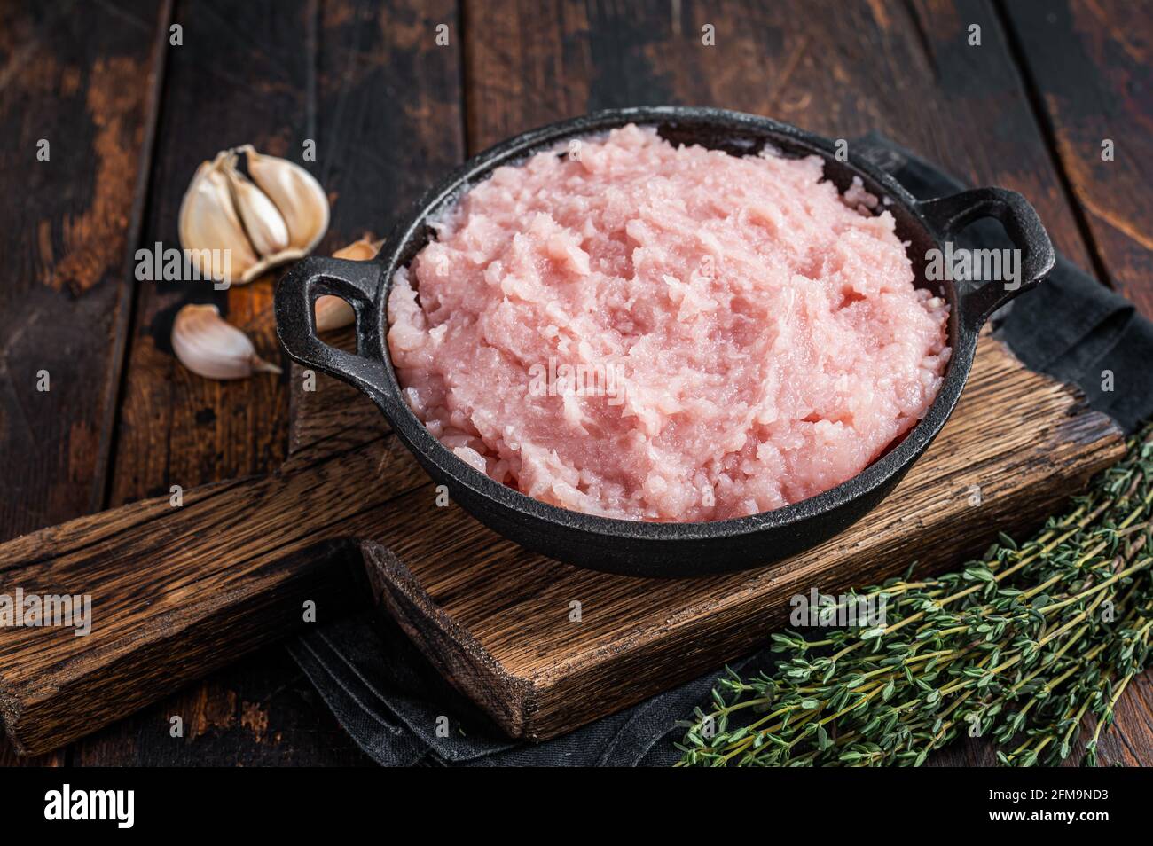 Uncooked Raw minced chicken and turkey meat in a pan with herbs. Dark ...