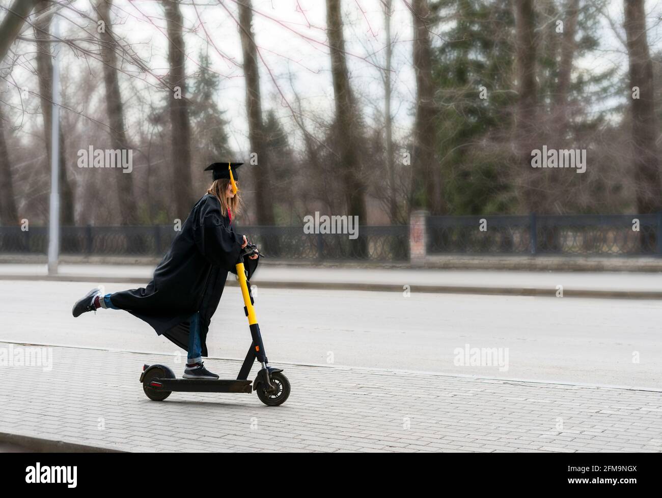 Happy Young woman in black graduation gown and black graduation cap ...