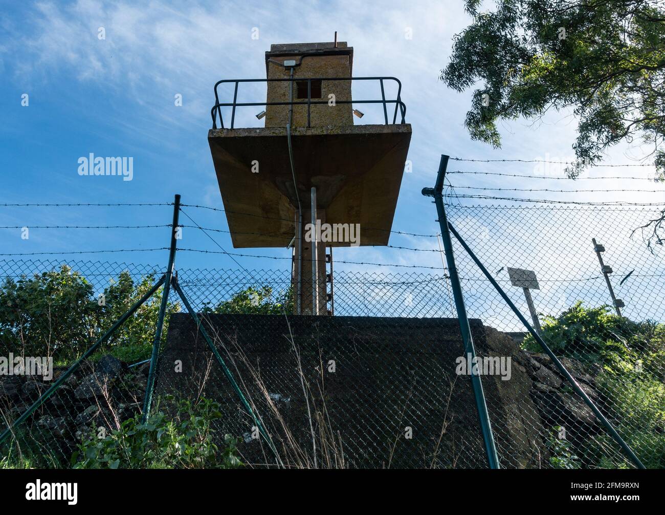 Watchtower behind security, razor wire, barbed wire fence Stock Photo ...