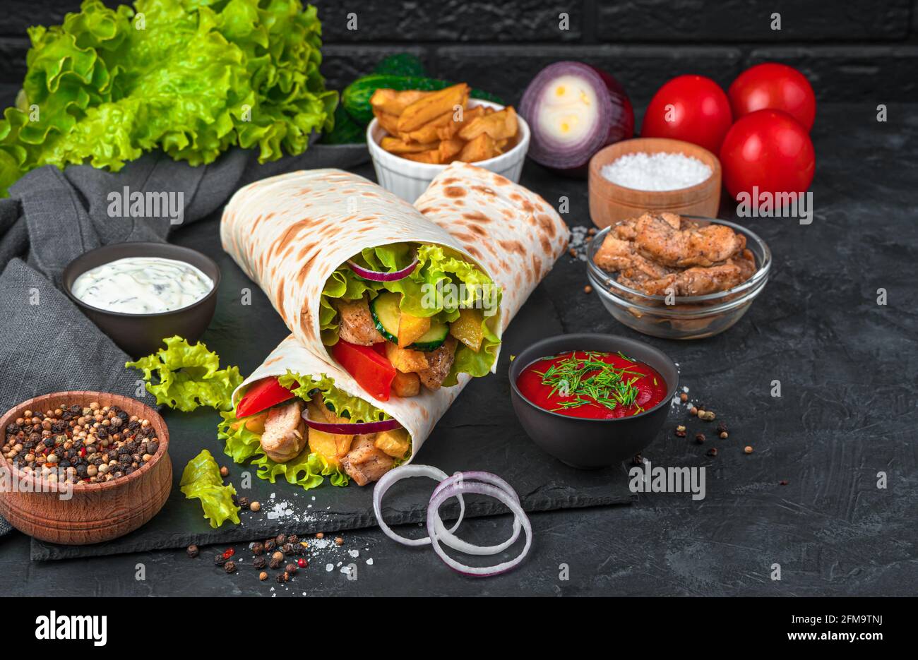 Shawarma and ingredients on a black background. Side view, copy space ...