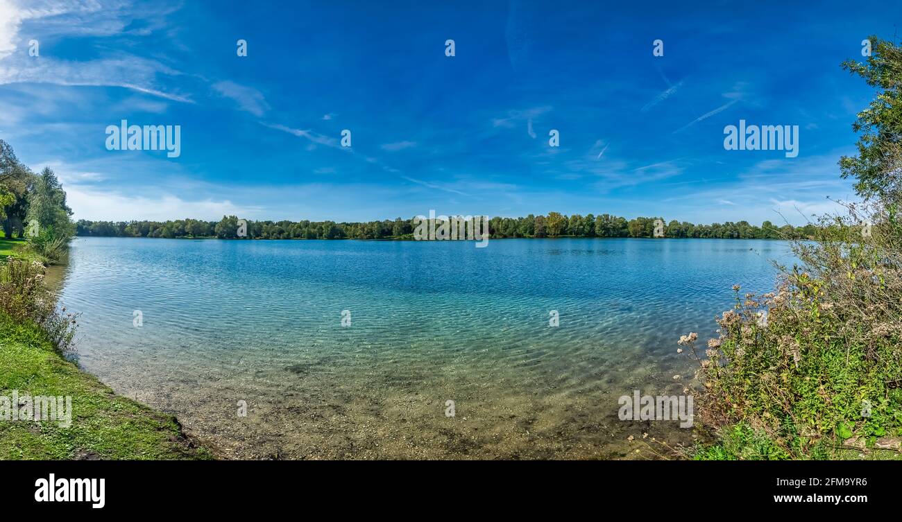 The beautiful, calm view over a panoramic big lake to the other shore ...
