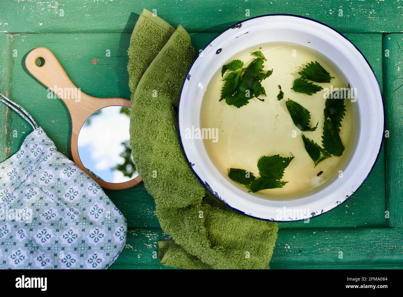 Nettle as a medicinal plant: view of an old enamel bowl with a facial ...