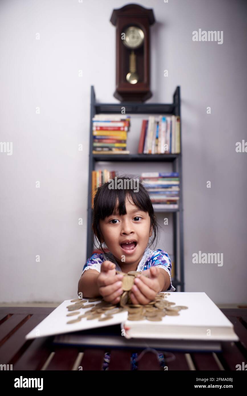 Little Girl holding bunch of gold coins Stock Photo - Alamy
