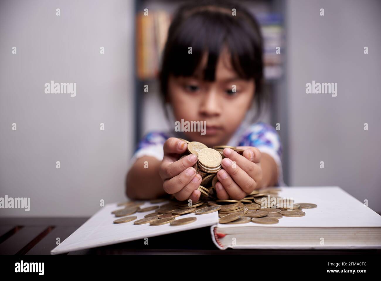 Little cute Girl is counting bunch of coins Stock Photo - Alamy