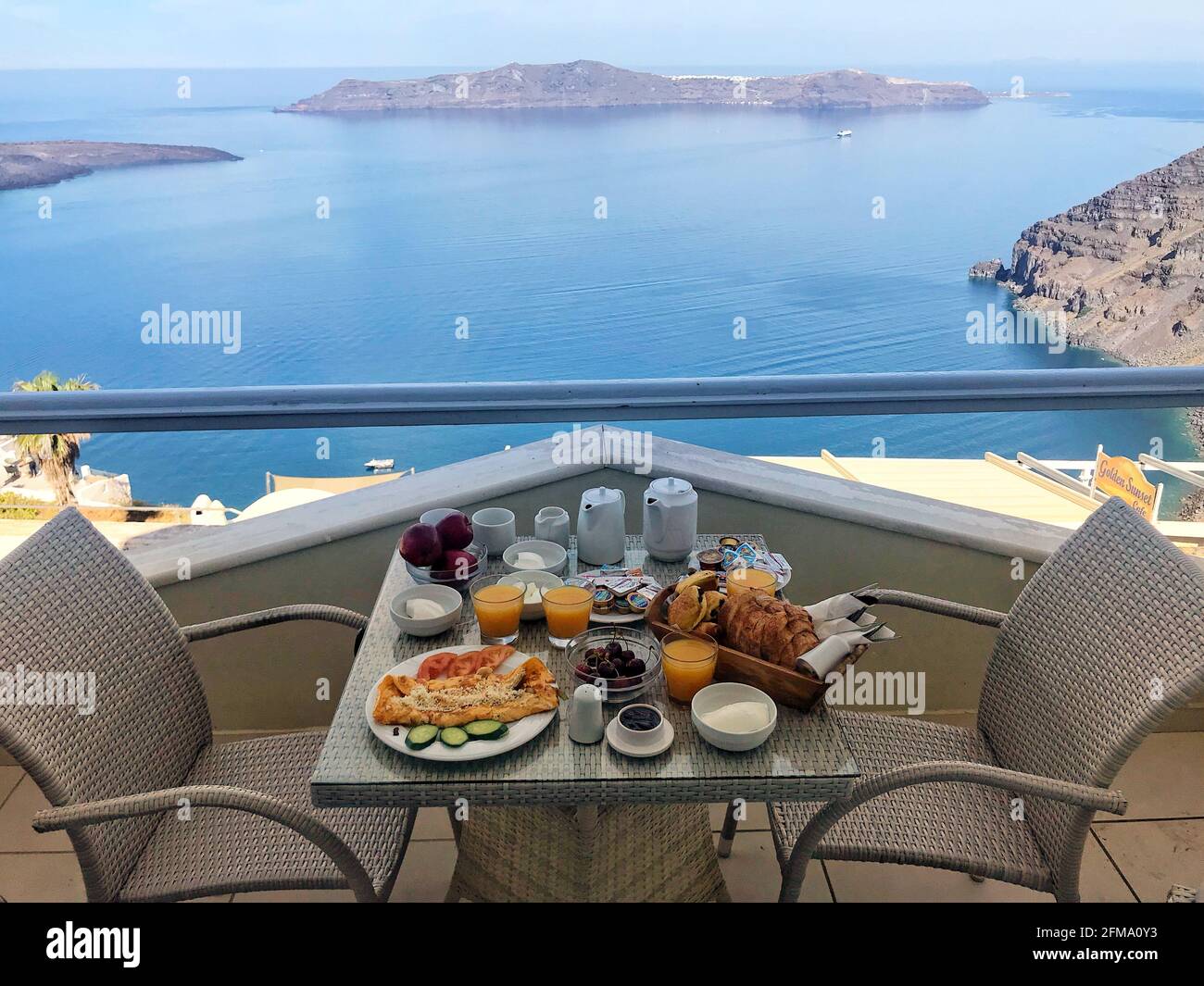 Closeup shot of a breakfast table overseeing blue ocean with small ...