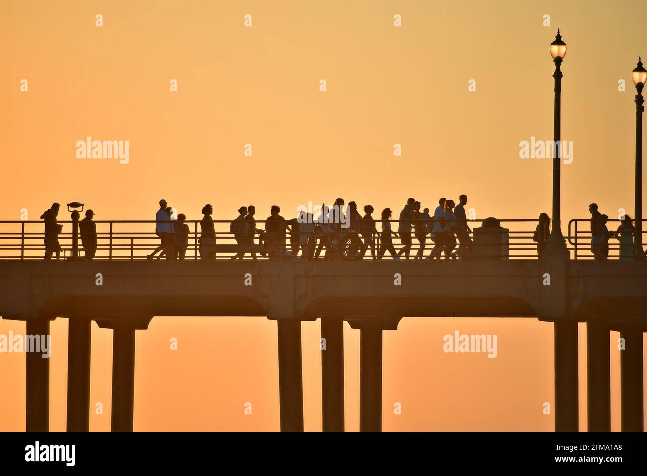 Sunset landscape with people silhouettes on Huntington Beach Pier in ...