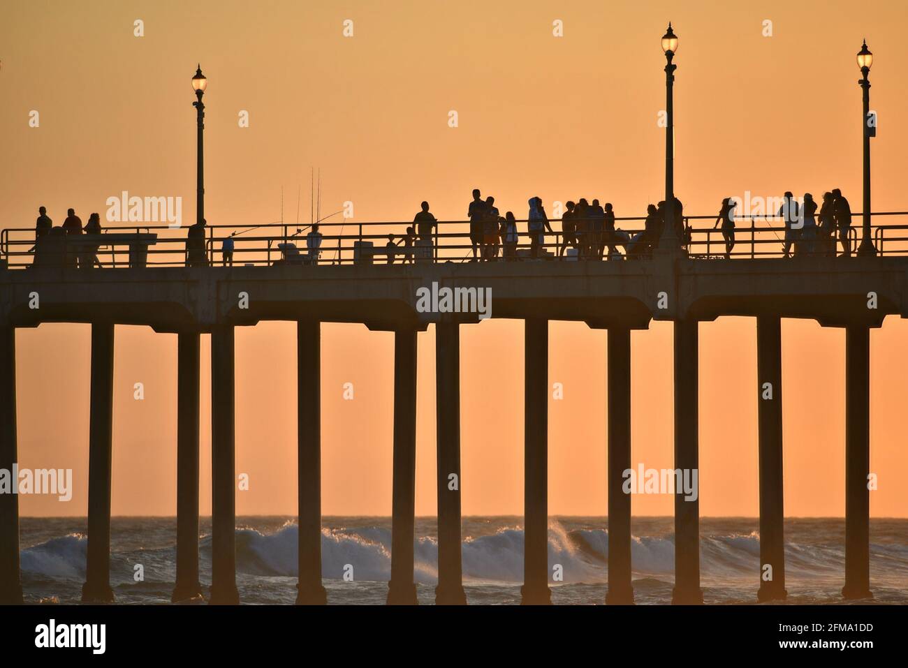 Sunset landscape with people silhouettes on Huntington Beach Pier in ...