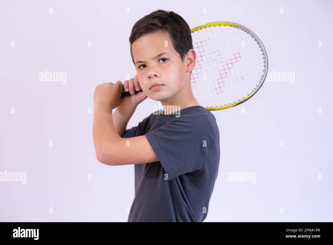 Cute young boy with tennis racket on white background Stock Photo - Alamy