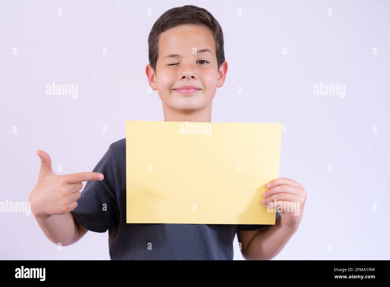 Smiling boy portrait winking holding blank paper. Isolated on white ...