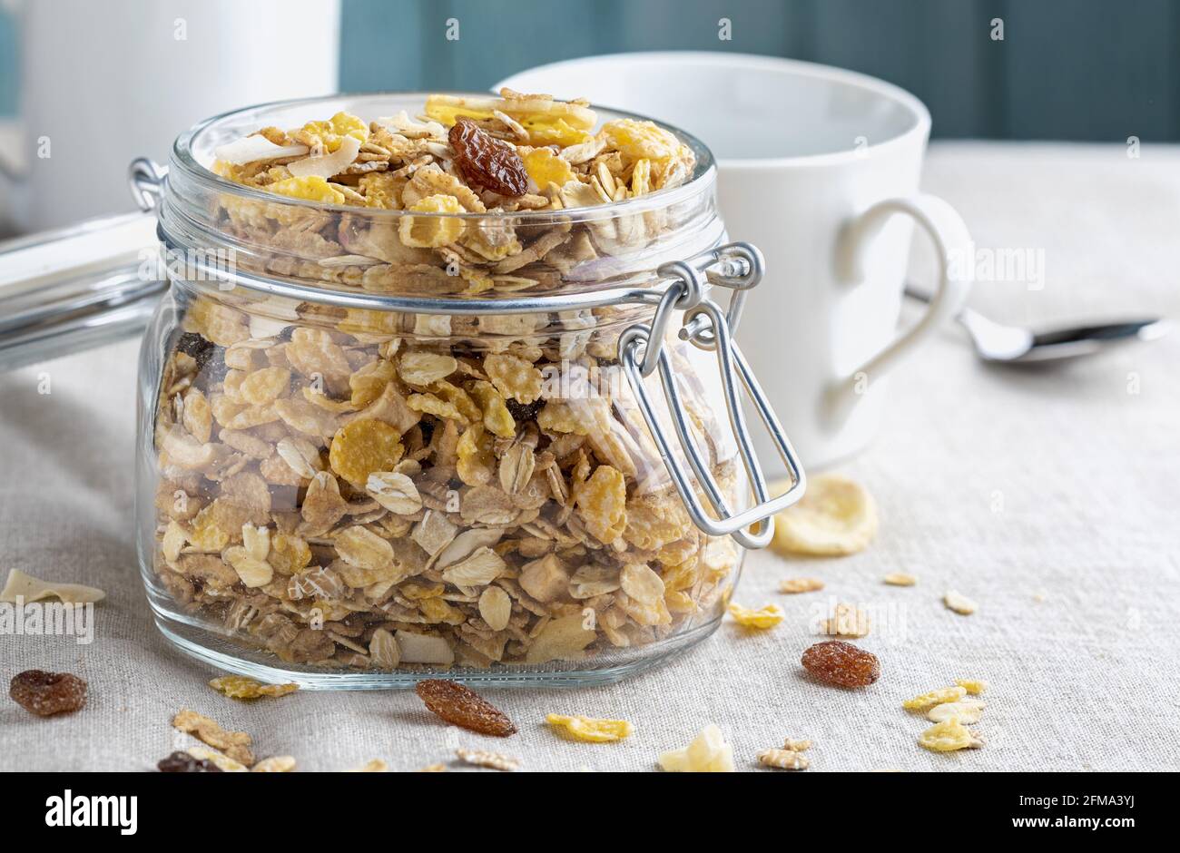 Glass jar with whole grains for breakfast. Muesli with dried fruits and ...