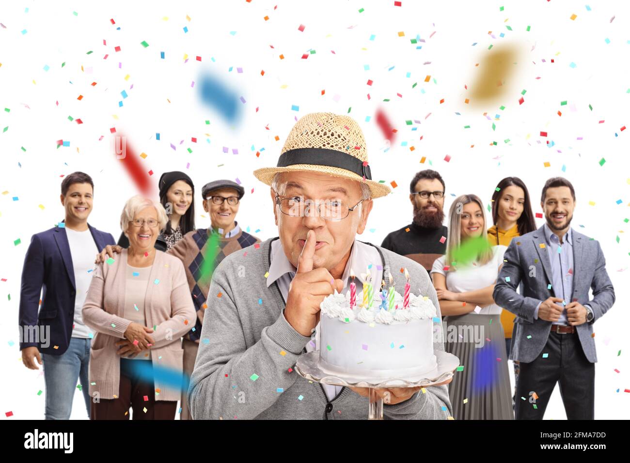 Elderly man holding a birthday cake for a surprise party with people ...