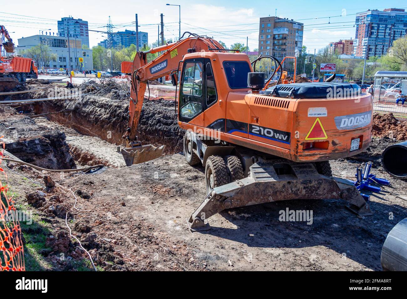 Samara, Russia - May 06, 2021: A modern excavator performs earthworks ...