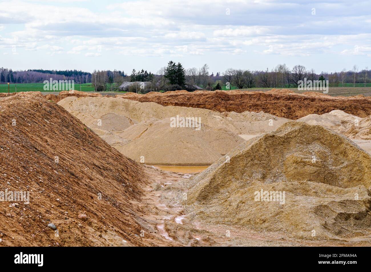 view of a gravel and pebble quarry with piles of materials of different ...