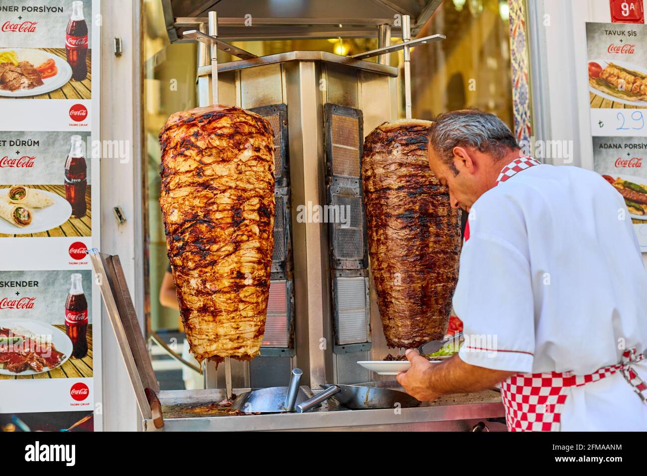 The chef prepares shawarma in a street counter in the open air. Turkish ...