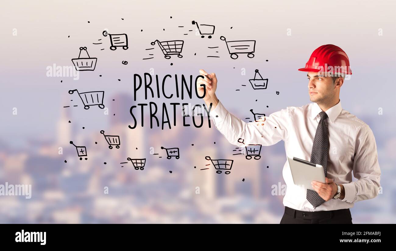 Young businessman with helmet drawing sale sign Stock Photo - Alamy