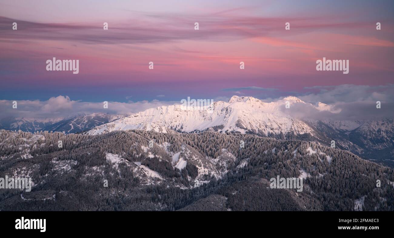 Winterly snowy mountain landscape after sunset. Brightly colored clouds ...