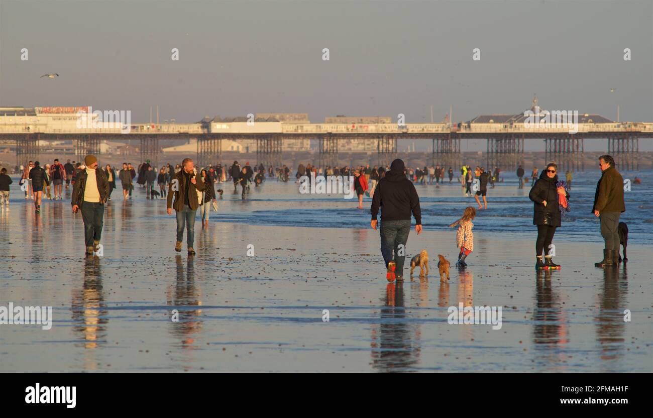 Beachgoers on Brighton beach during a low tide, late afternoon, spring ...