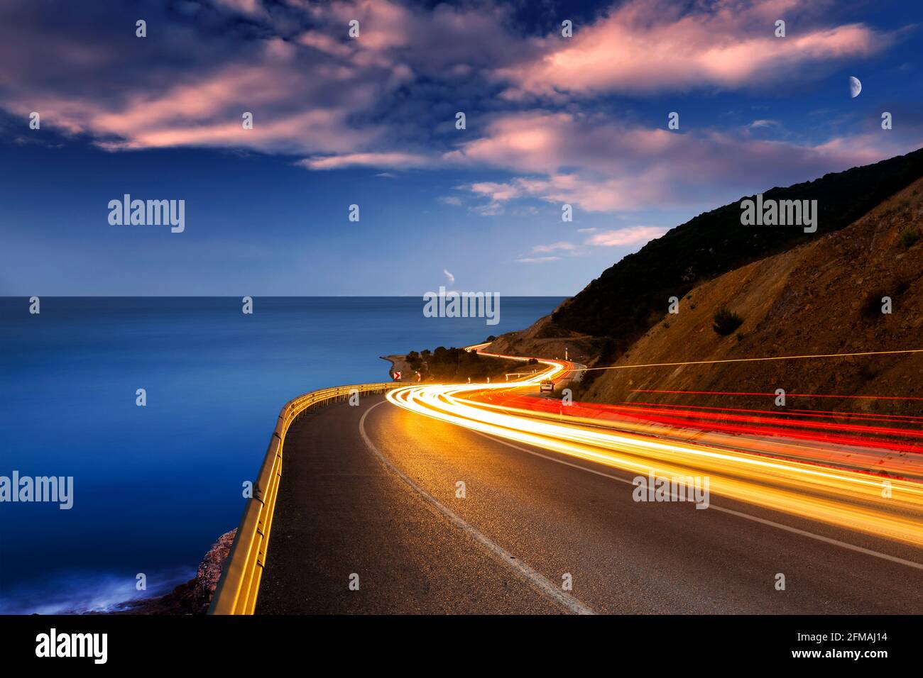 car lights on the night beach road. Car lights on the sea and highway ...