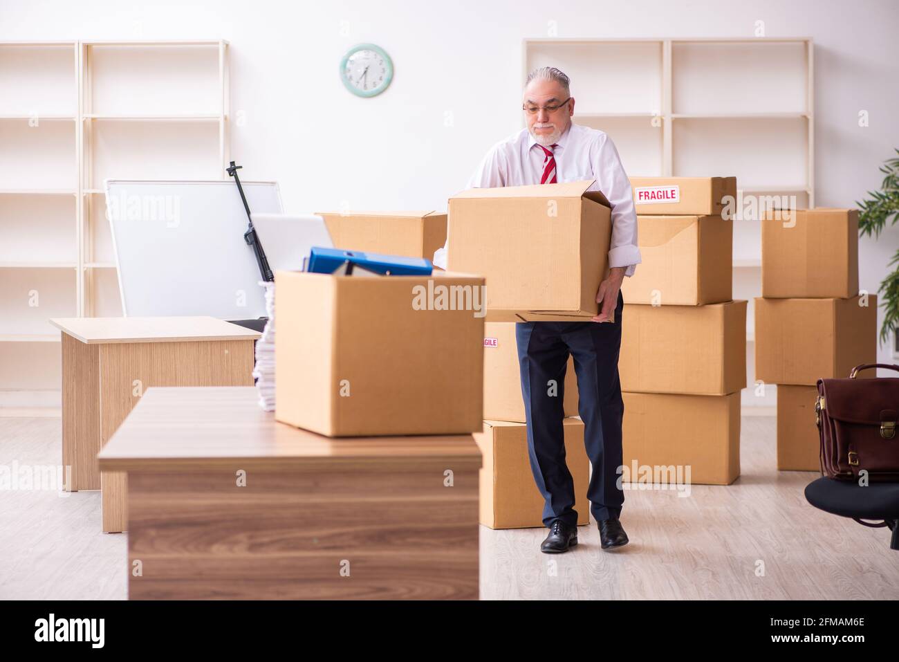 Old male employee in relocation concept Stock Photo - Alamy