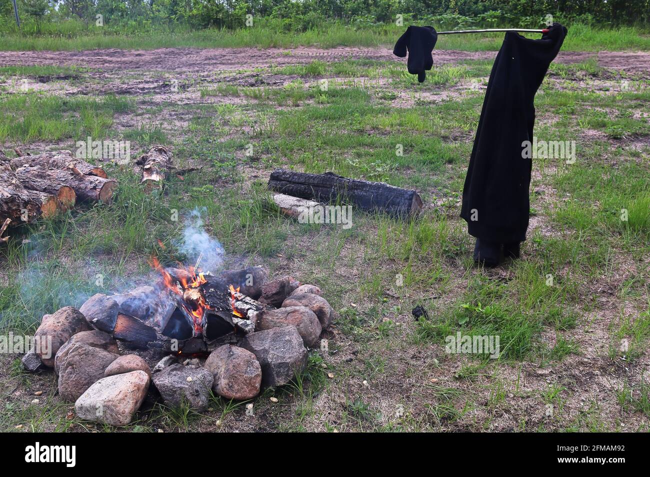 Various pieces of clothing drying by a campfire Stock Photo - Alamy