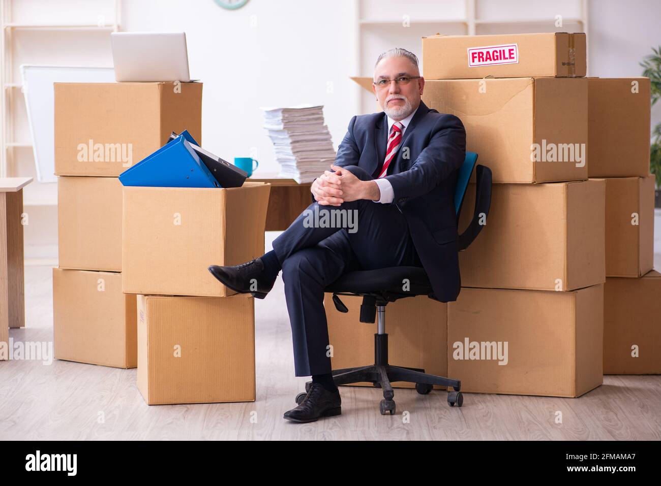 Old male employee in relocation concept Stock Photo - Alamy