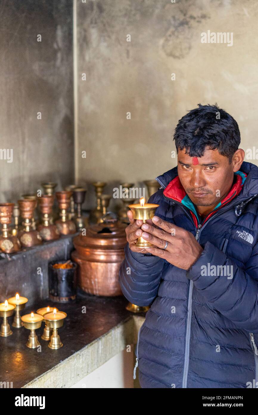 Porter lights butter lamp in temple of pilgrimage site Muktinath ...