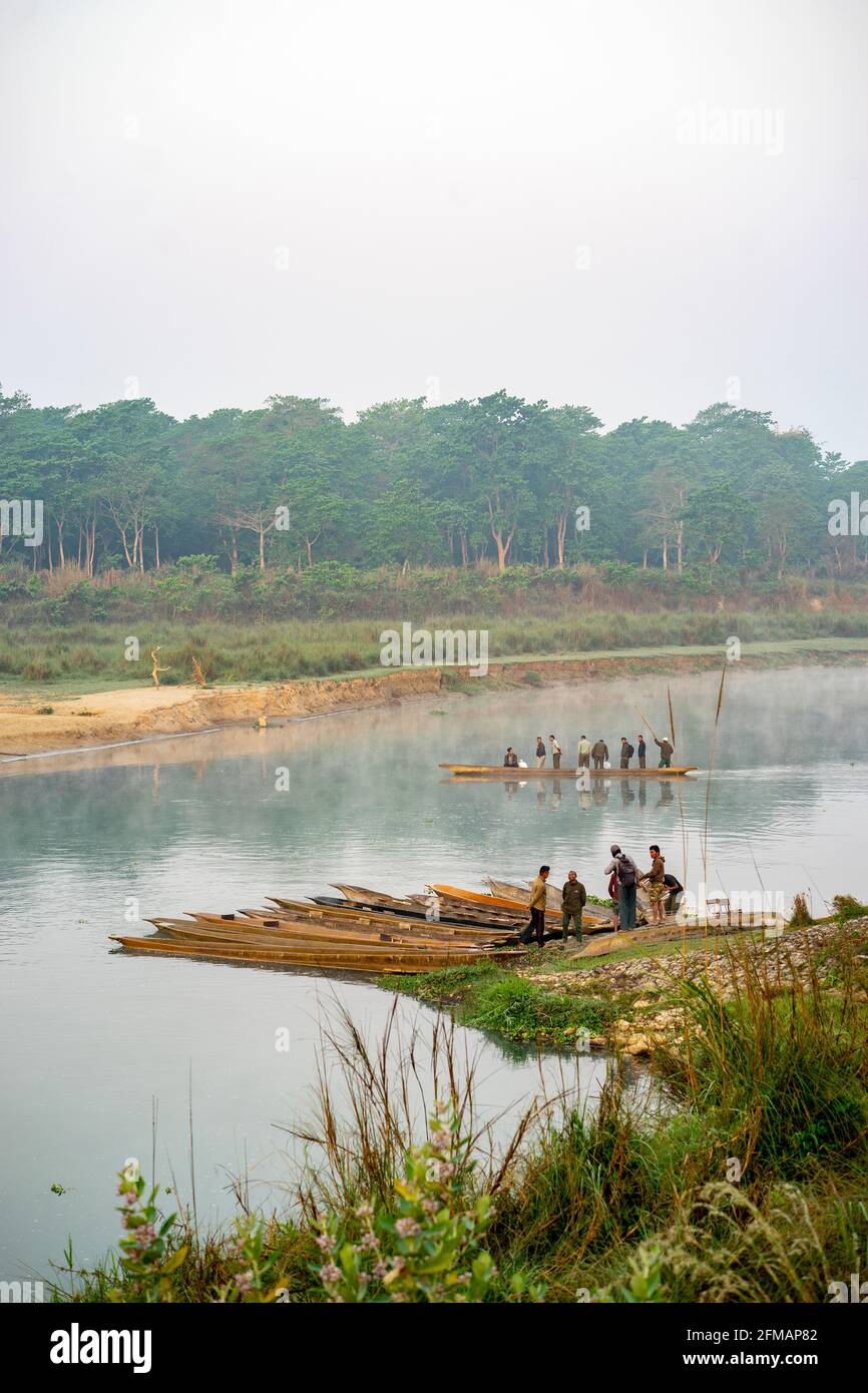 Tourists cross the Rapti River in a dugout wooden canoe, Chitwan ...
