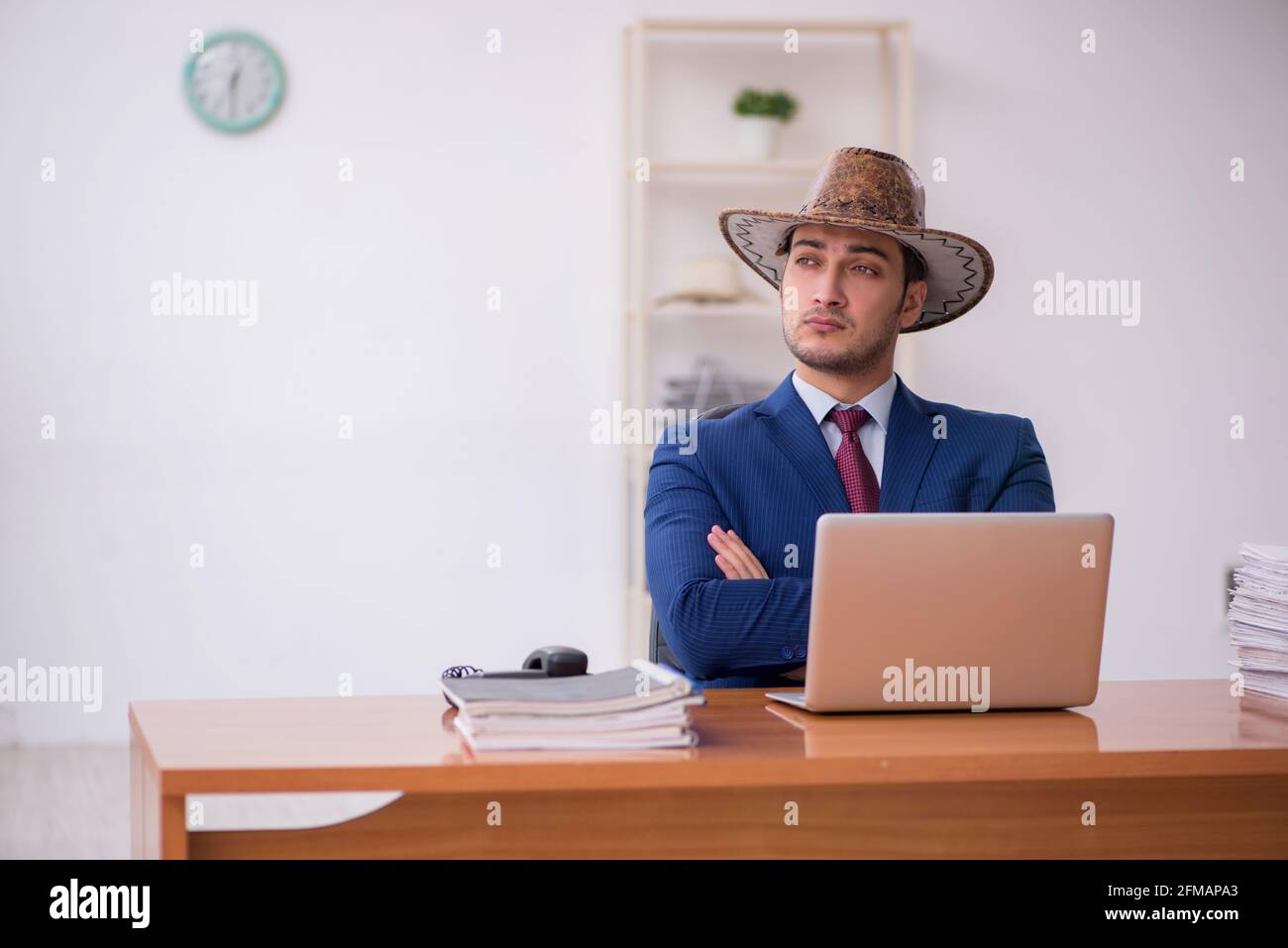 Young cowboy employee working at workplace Stock Photo - Alamy