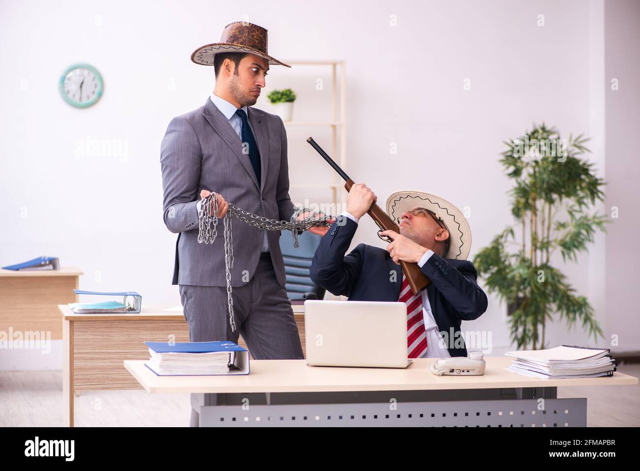 Two cowboy employees in funny concept Stock Photo - Alamy