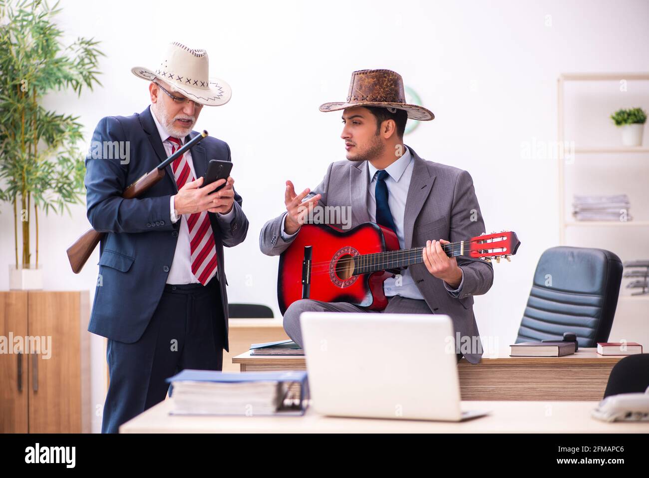 Two male cowboy employees during break in the office Stock Photo - Alamy